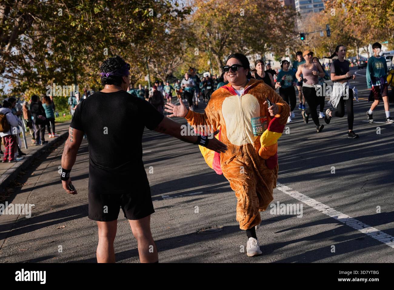 A woman wearing a turkey costume runs during the Oakland Turkey Trot in ...