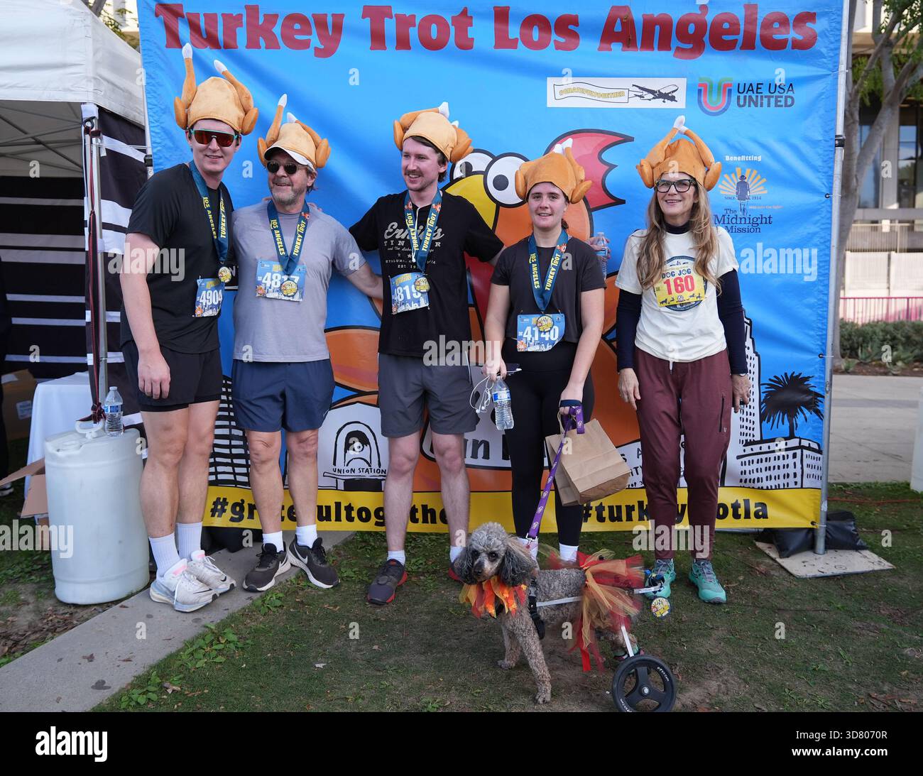People take pictures after completing the Turkey Trot LA 2025, a fundraiser race for The ...