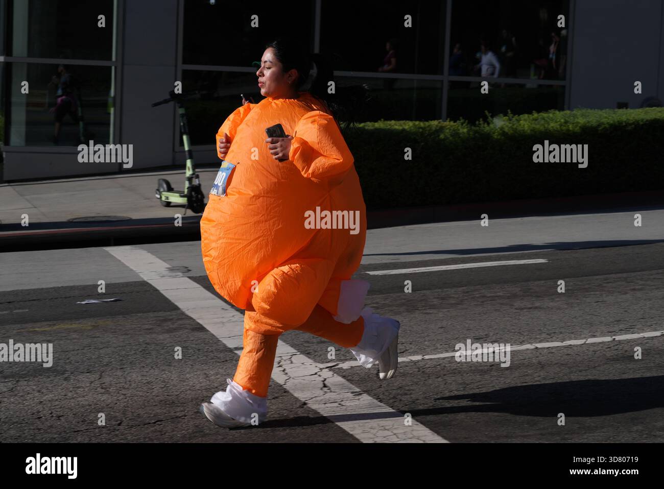 A runner dressed as a turkey races down hill the Turkey Trot LA 2025, a ...