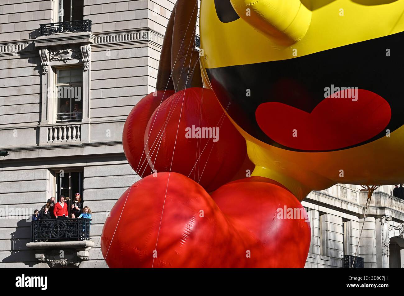 People watch the PacMan balloon float by from a balcony on Central Park ...