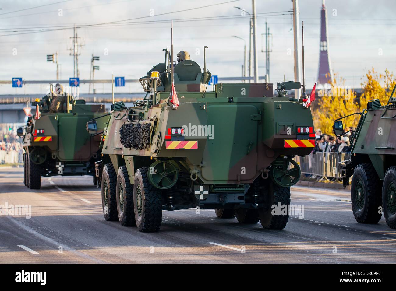 NATO allied armored 8x8 military vehicles driving along an urban road ...