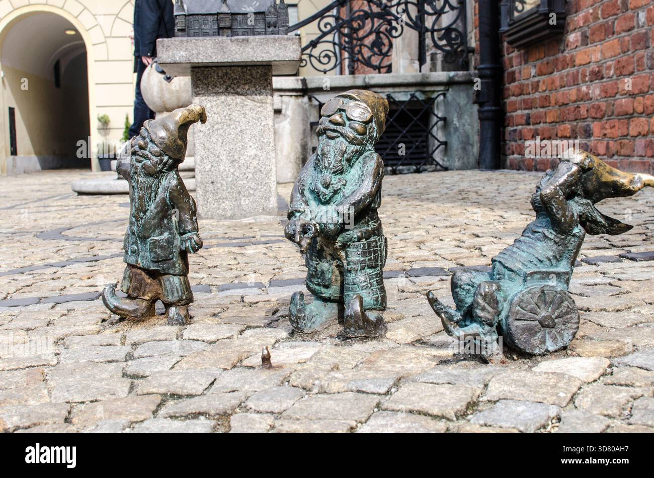 Bronze Wrocław dwarf statues displayed on a cobblestone street in the ...