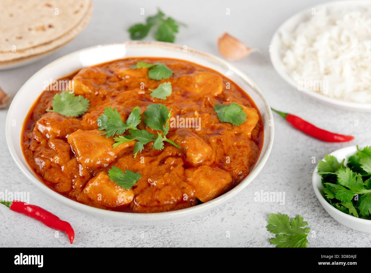 Traditional Indian butter chicken curry in a bowl with rice and roti ...