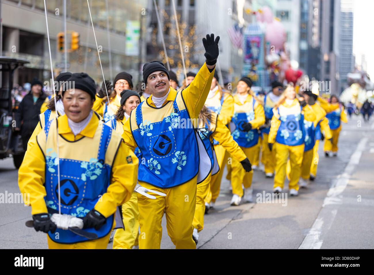 A participant in the 99th Annual Macy's Thanksgiving Day Parade waves ...