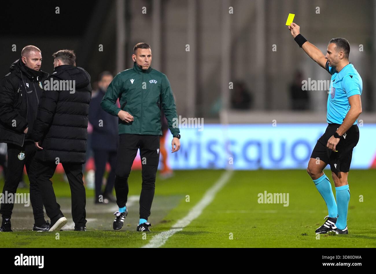 Referee Filip Glova (right) shows a yellow card to Shamrock Rovers ...
