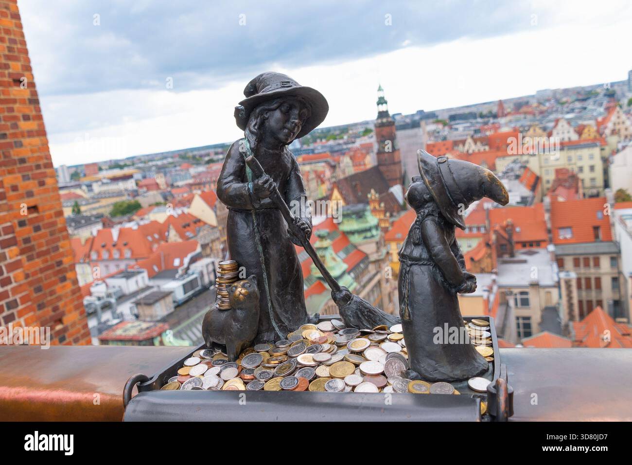 Bronze sculptures with coins overlooking old european cityscape. Tekla ...