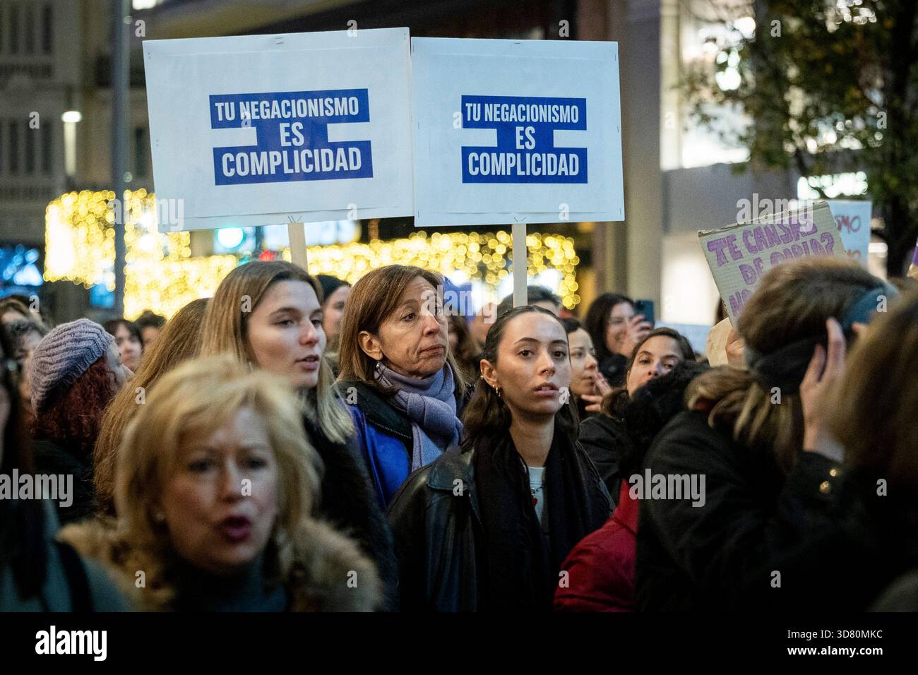 Some protesters hold a banner with the slogan 'your denialism is ...