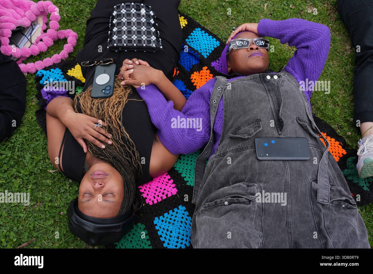 FILE - Participants hold hands as they lie on the ground during a ...