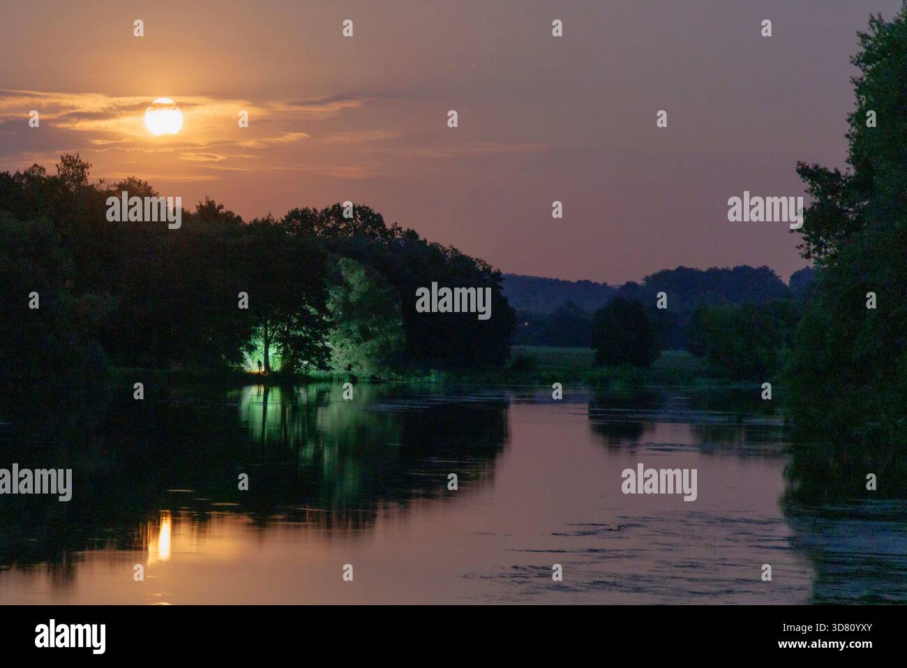 full moon rising over the River Regen at dusk, with illuminated fishing ...