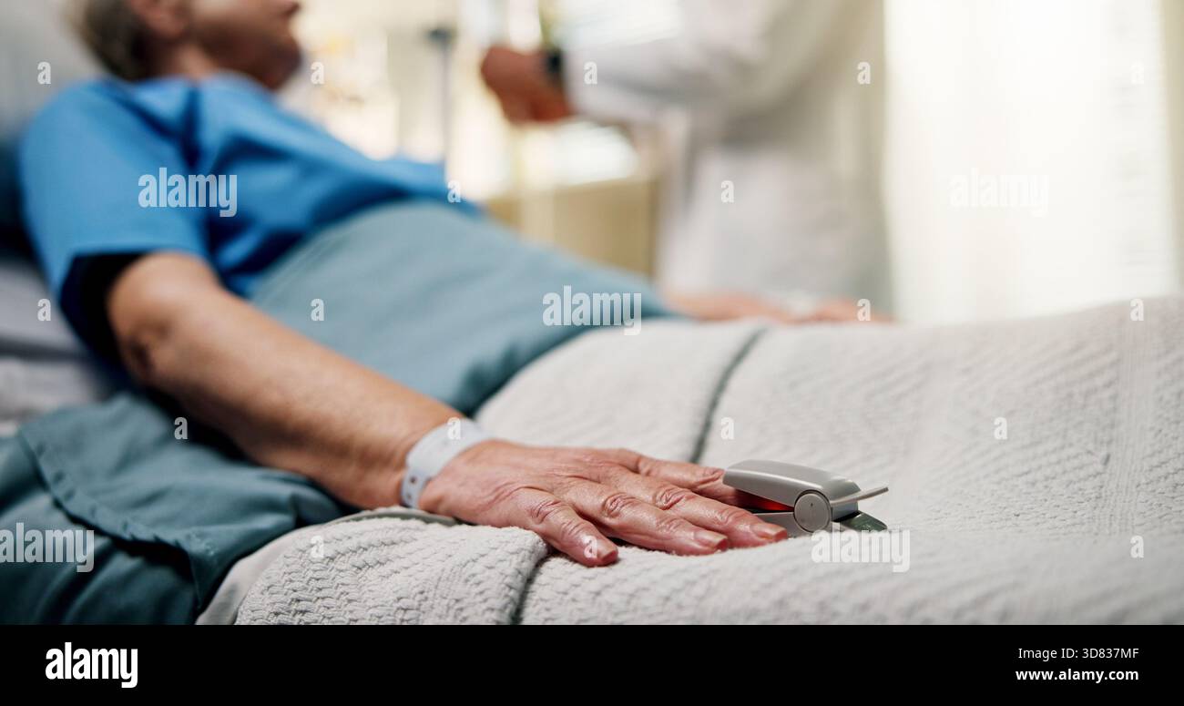 Hands, senior person and oximeter in hospital bed to monitor pulse ...