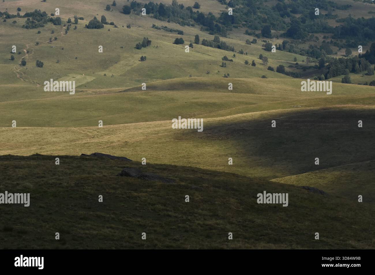 Gentle green hills stretch across the landscape, bathed in soft ...