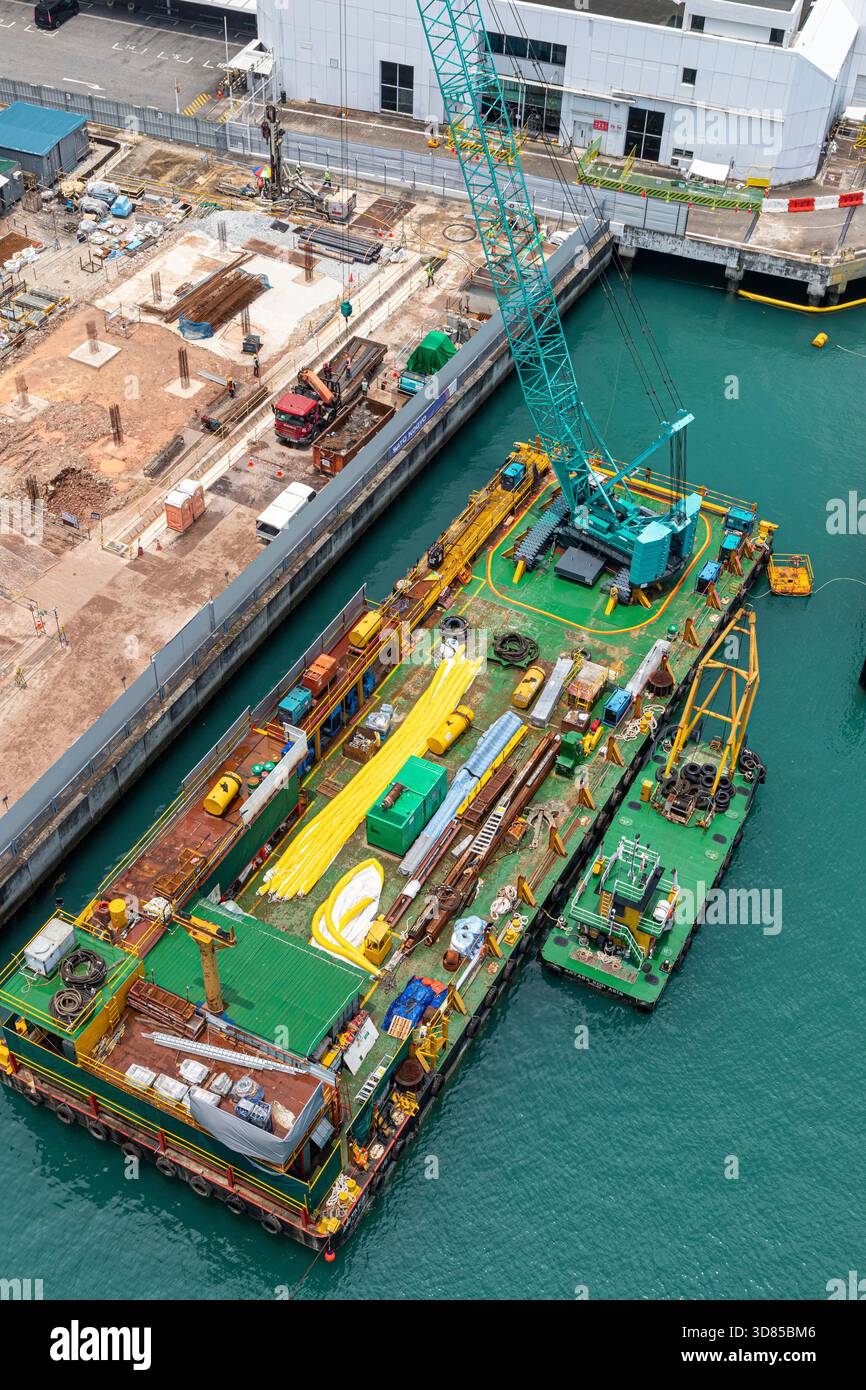 A floating barge working on a building construction site beside ...