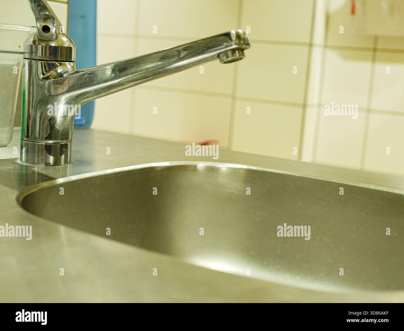 Stainless steel kitchen sink with chrome faucet in professional ...