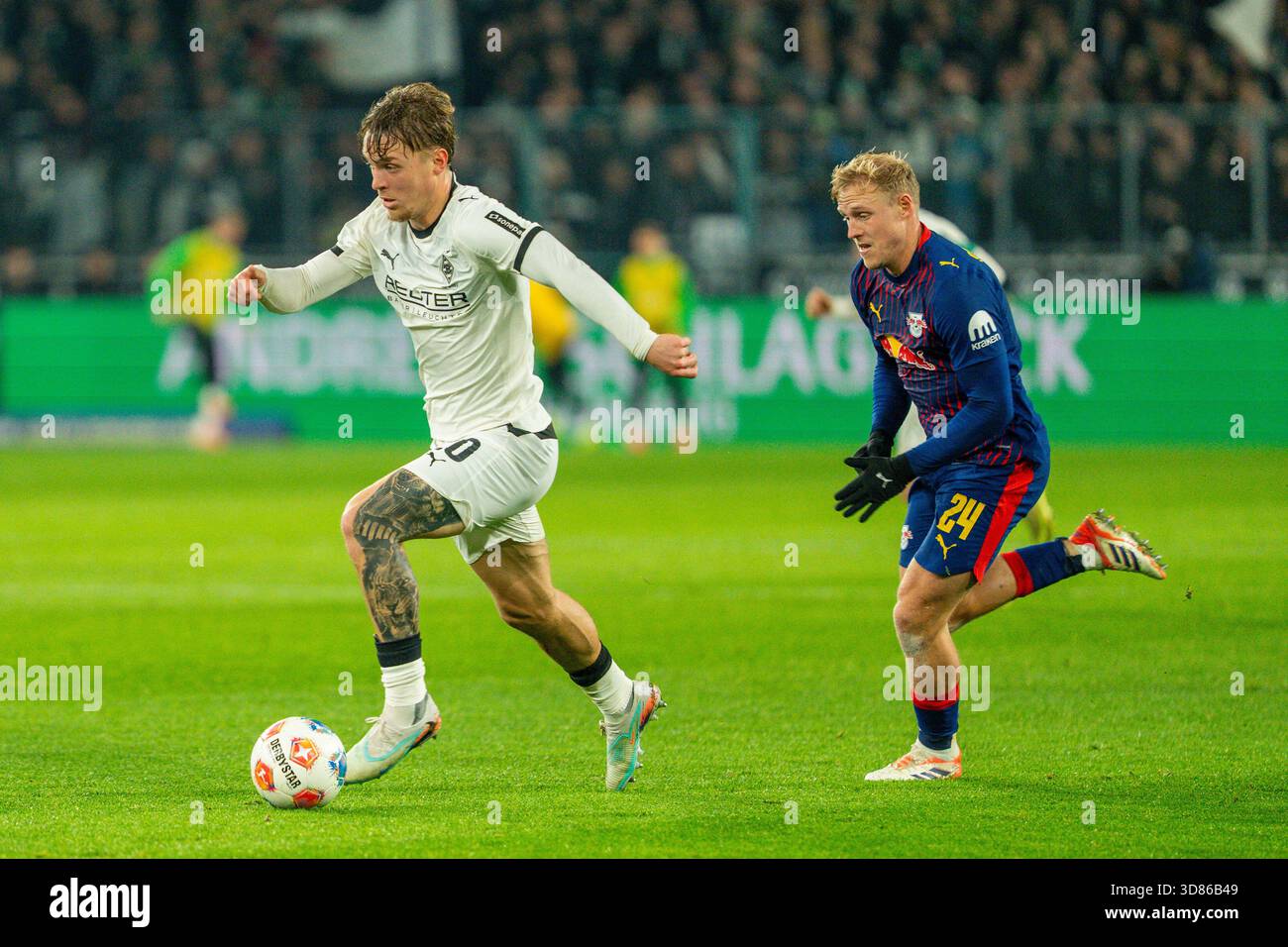 Luca Netz (Borussia Borussia Monchengladbach, #20) on the ball, behind ...