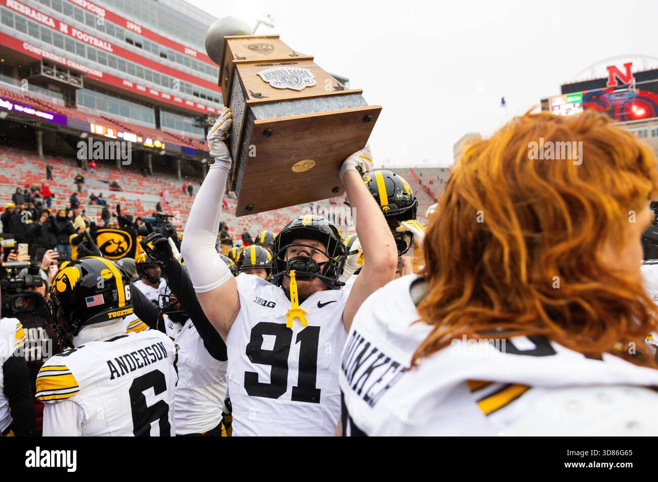 Iowa defensive lineman Jonah Pace (91) hoists the Heroes Game Trophy ...