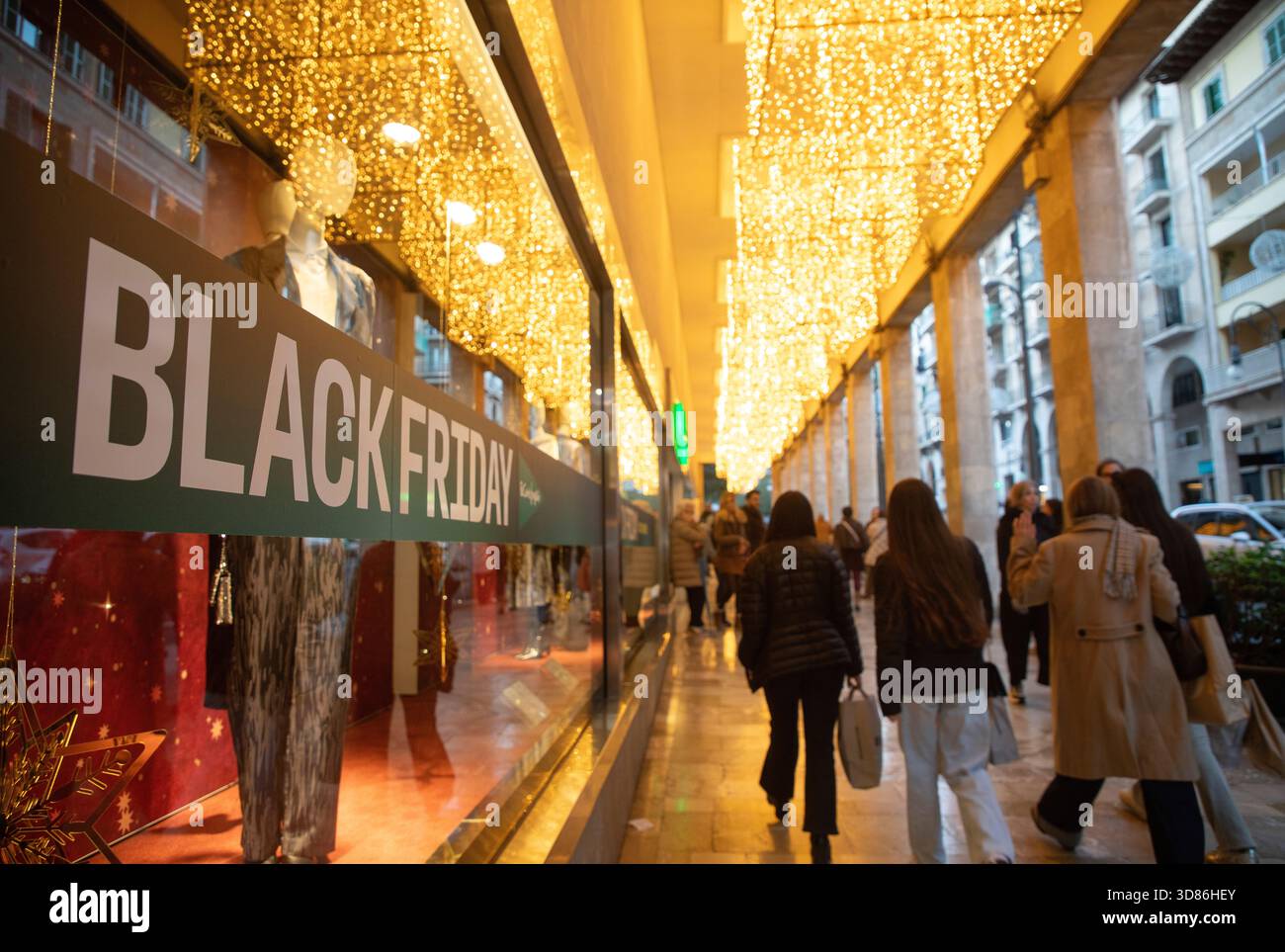 28 November 2025, Spain, Palma: People walk through the shopping ...