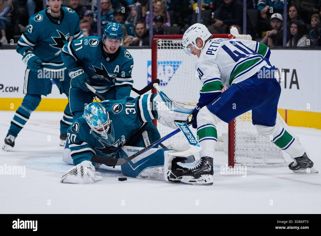 San Jose Sharks goaltender Yaroslav Askarov (30) stops a shot by Vancouver Canucks center Elias ...