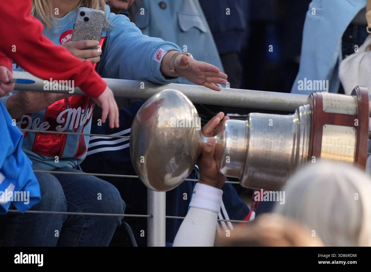Mississippi fans reach for "The Golden Egg" trophy their team won with ...