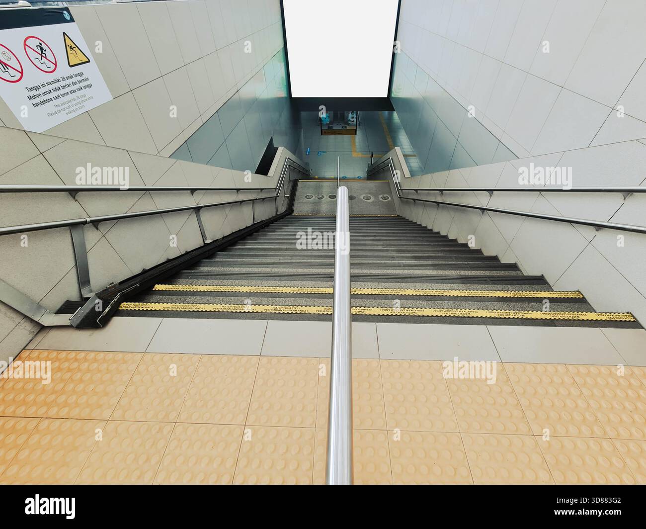 Symmetrical view down the stairs into a Jakarta MRT station, showing ...