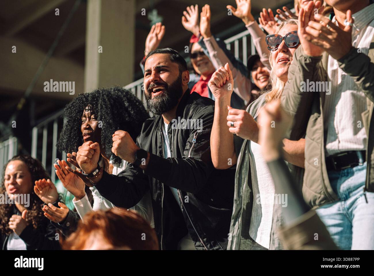 Happy enthusiast man making fist while cheering from sports stadium ...