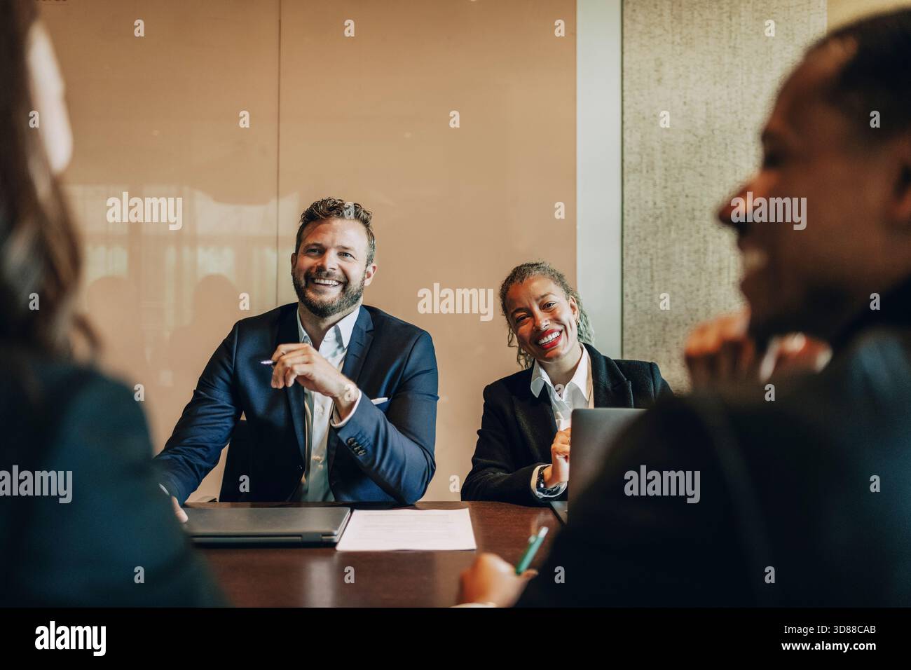 Happy male and female law experts sitting in meeting room at office ...