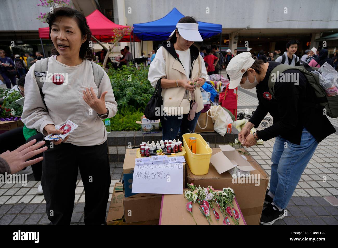 Heidi Lam, 50, a psychological counselor, at left is seen distributing ...