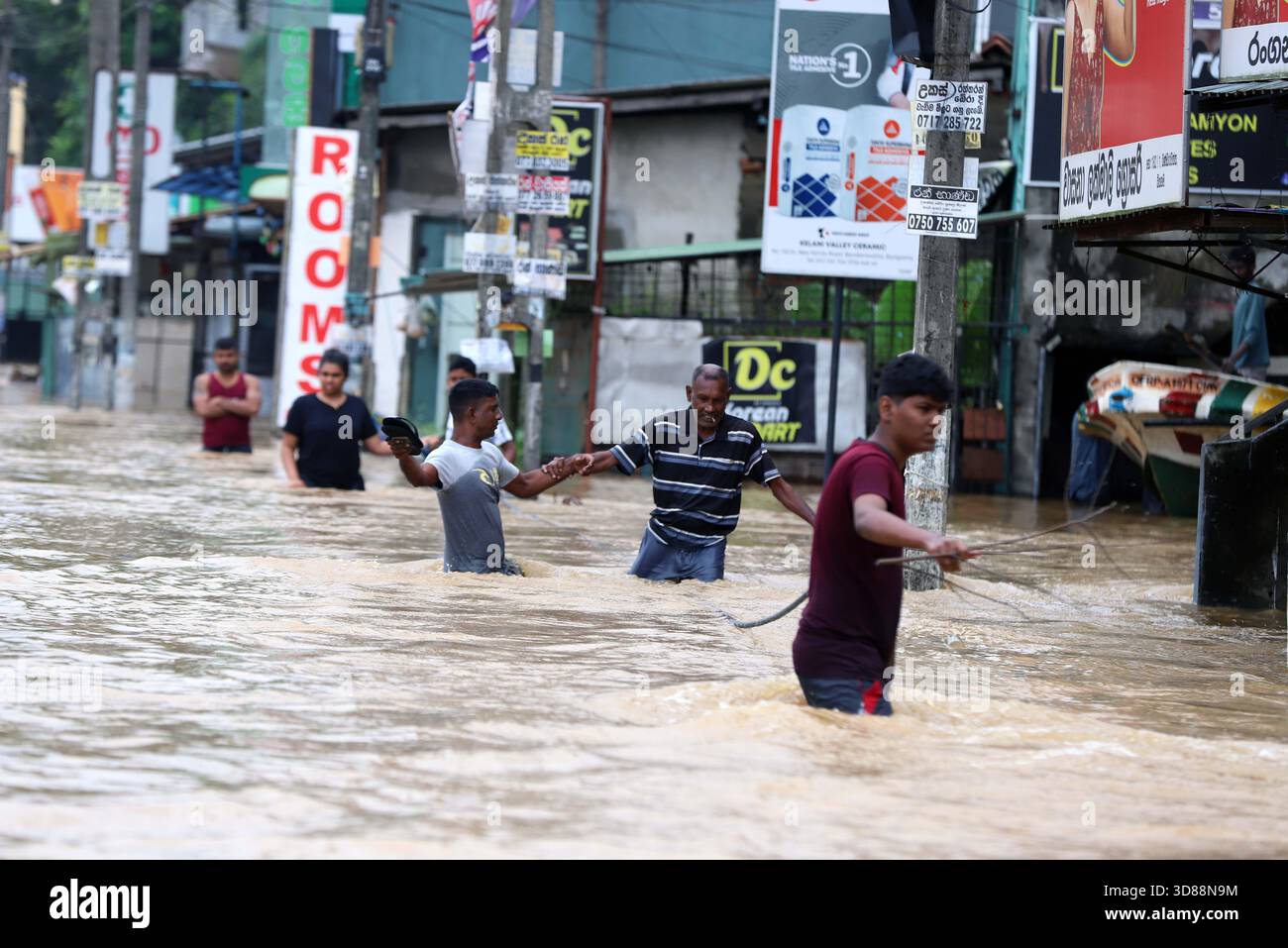 Colombo, Sri Lanka. 29th Nov, 2025. People evacuate by wading through ...