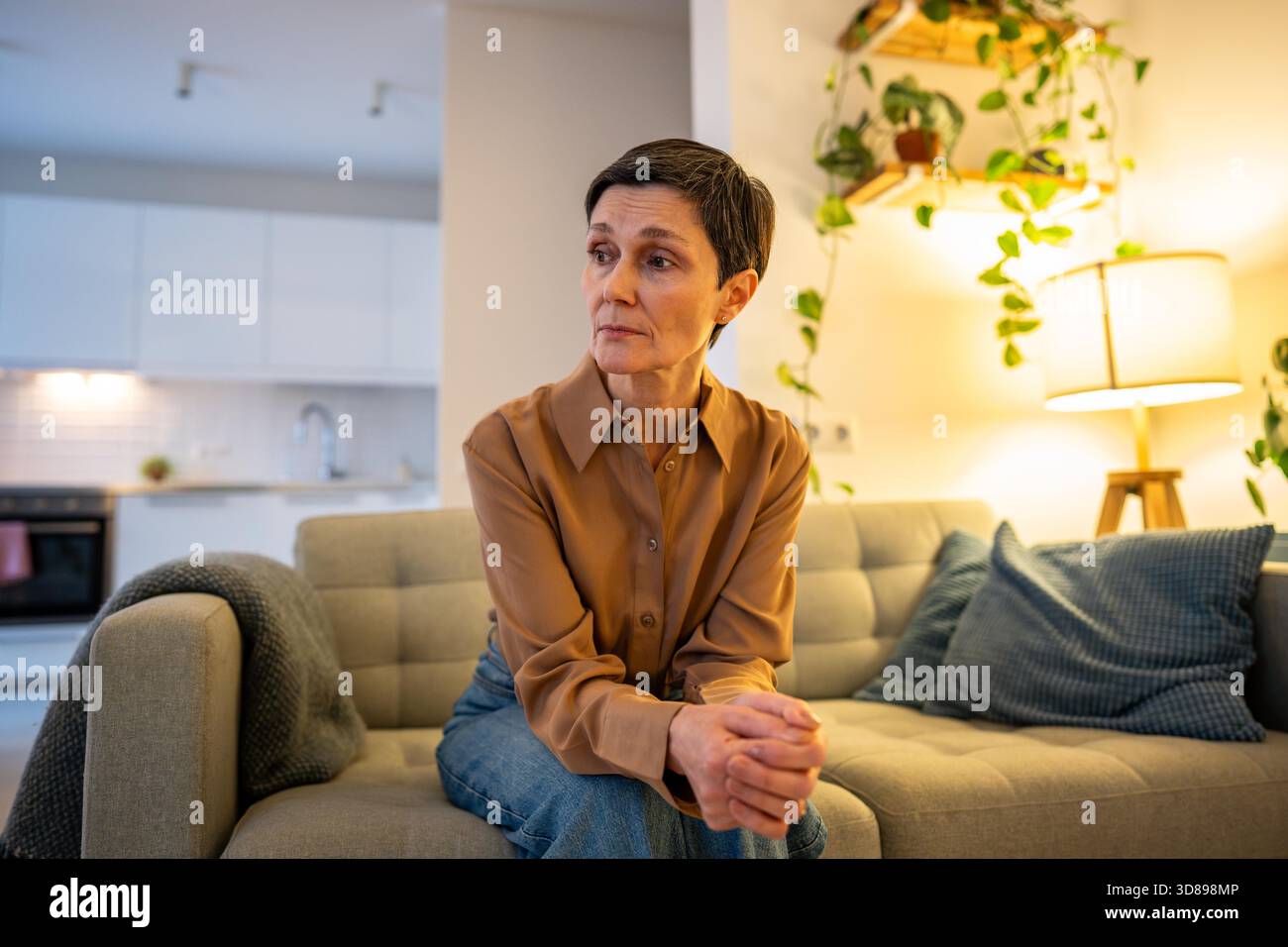 Upset mature woman with crossed arms wait on couch, tense concern ...