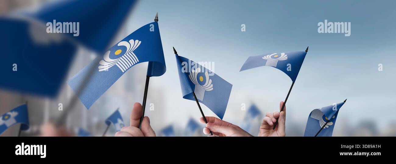CIS flags in their hands on a blurred urban background. The photo ...