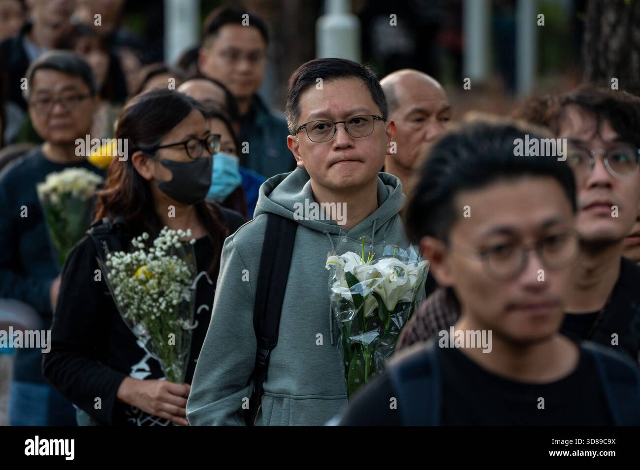 People in line to lay flowers near the scene of where a major fire ...
