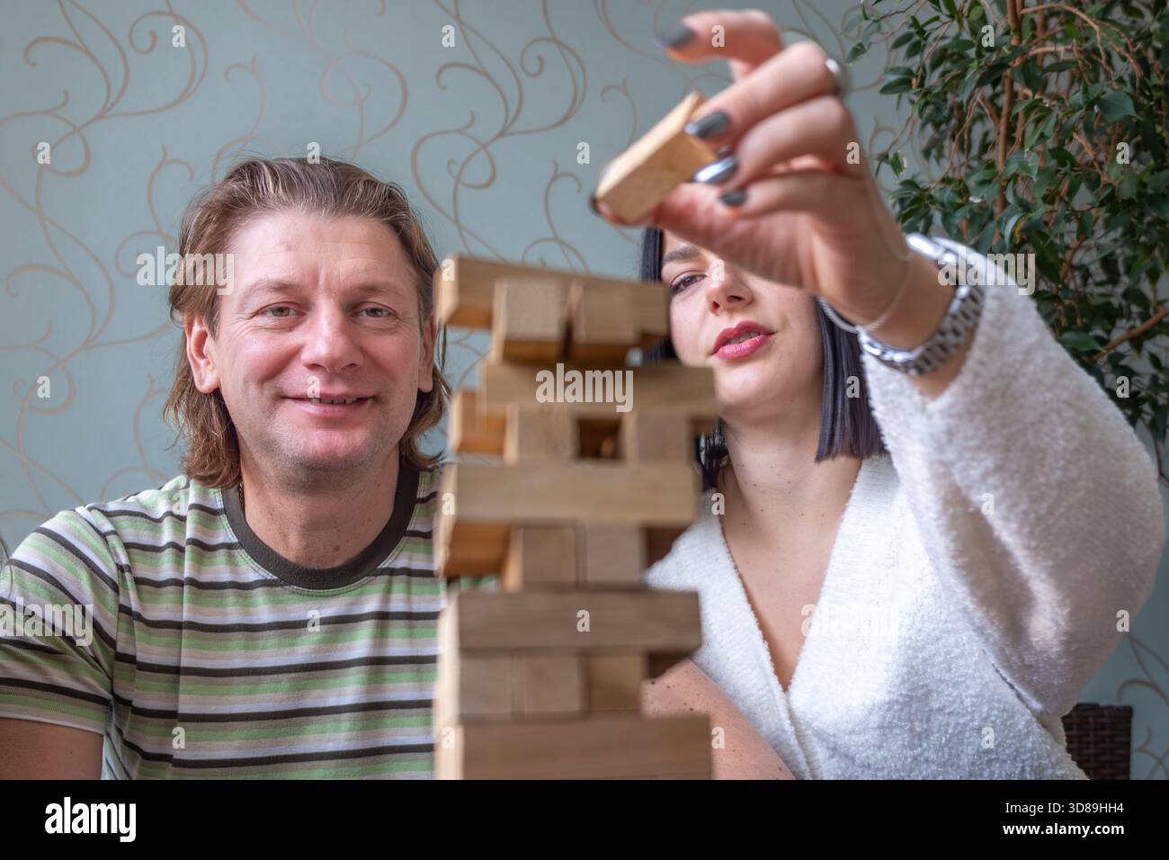Jenga game being played on a table, featuring wooden blocks stacked ...