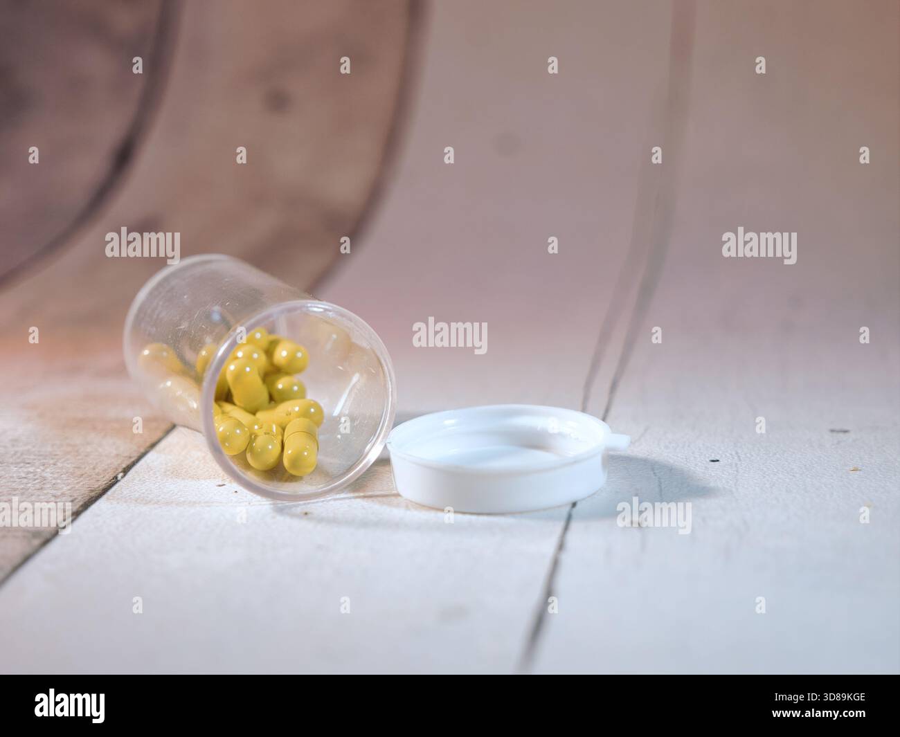 Yellow Capsules Spill from Pill Bottle - Yellow oval capsules spill out ...