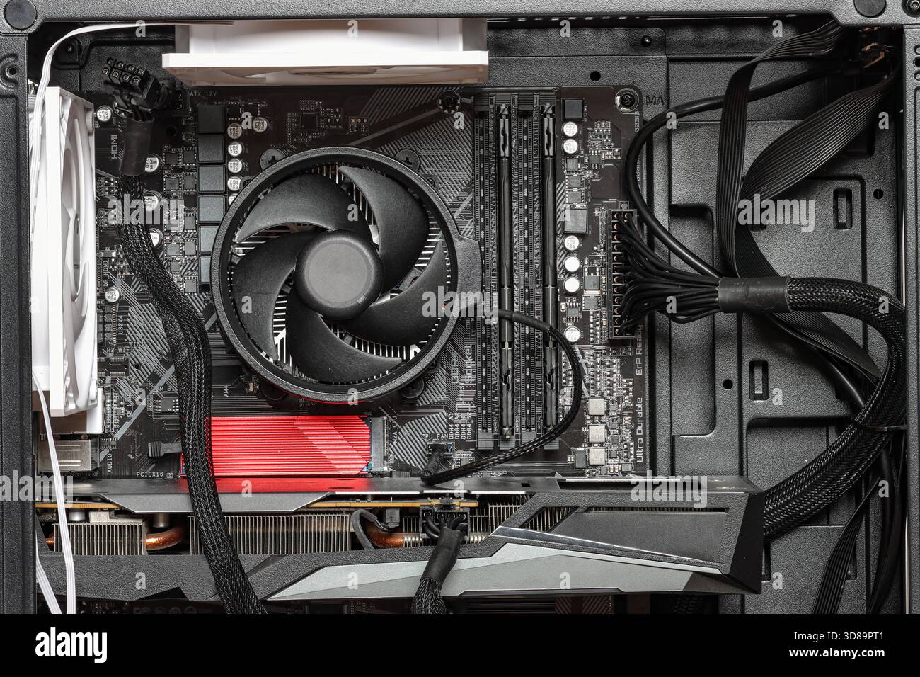 An open-side view of a gaming desktop reveals a cooling fan, graphics ...
