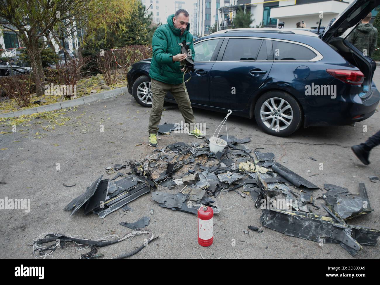 A man holds a fragment of a Russian UAV at a housing estate damaged by ...