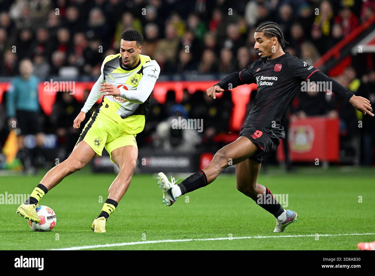 Bayer's Loïc Badé, right, and Borussia's Felix Nmecha fight for the ...