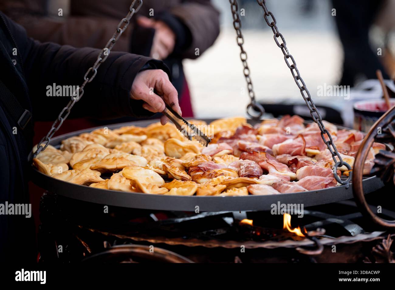 Oscypki are grilled on a barbecue at the Cracow Christmas Market on the ...