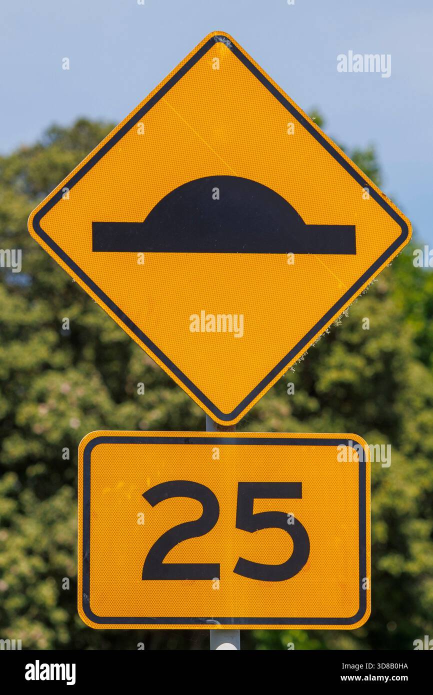 A warning traffic sign indicating a speed bump ahead alongside a 25 mph ...