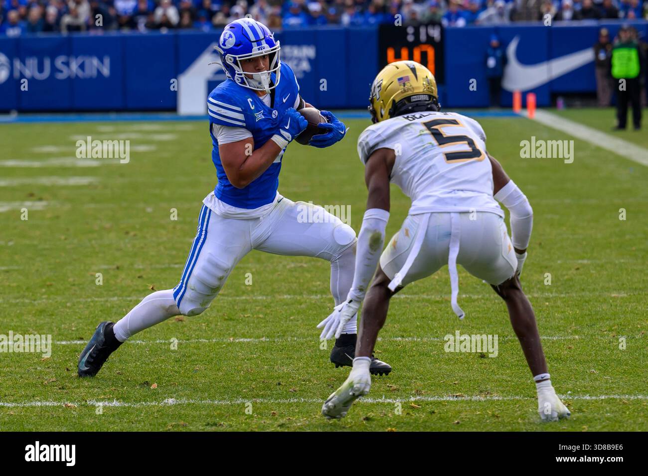 BYU running back LJ Martin, left, runs the ball as UCF defensive back ...