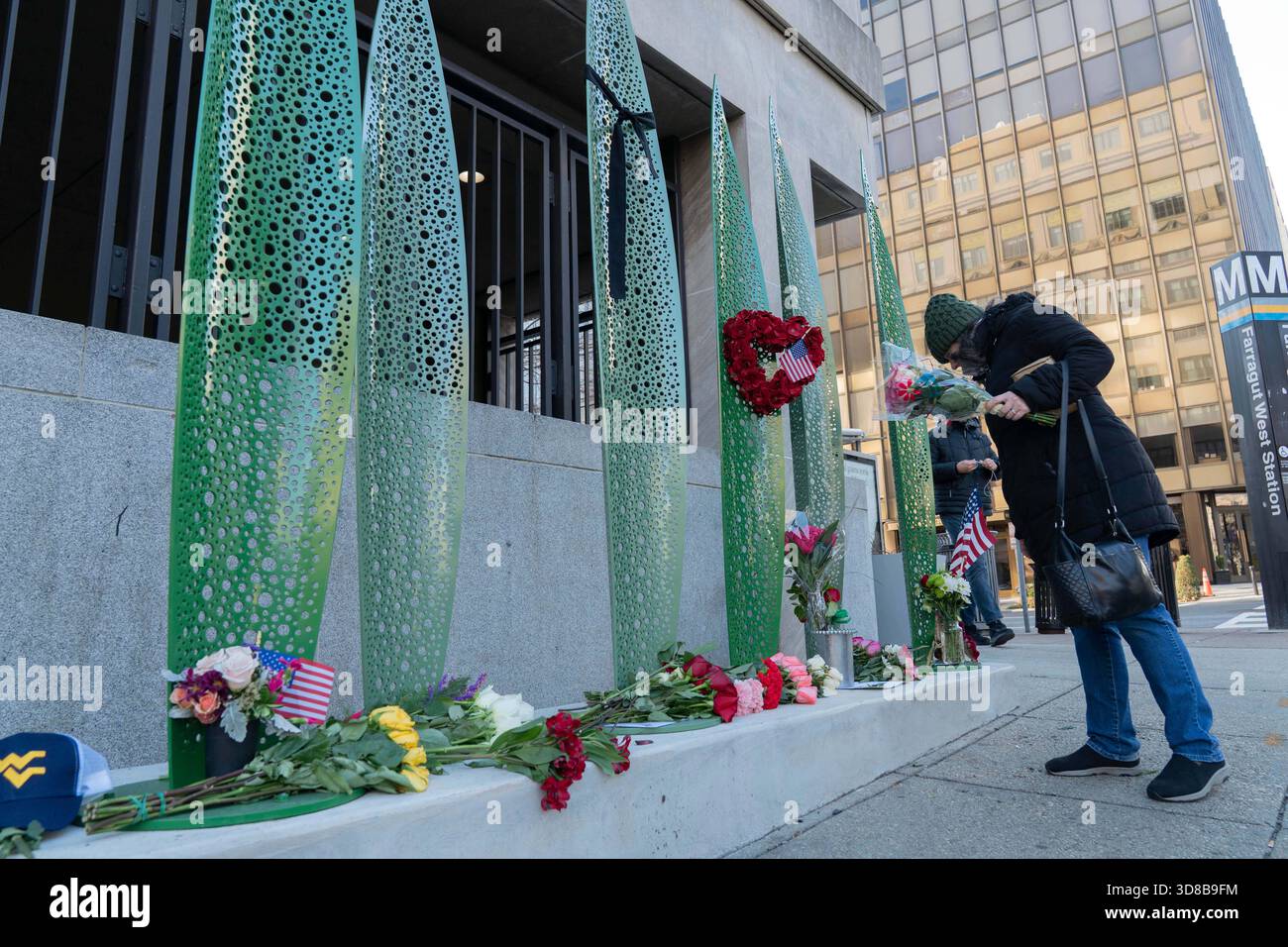A person brings flower to a makeshift memorial set up outside the metro ...