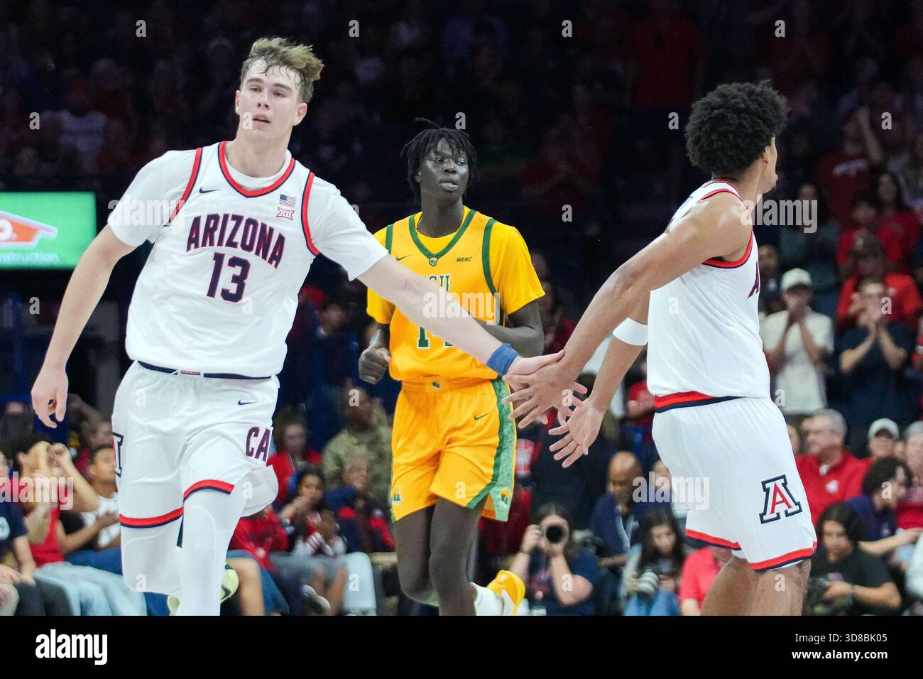 Arizona center Motiejus Krivas (13) gives a behind the back hand slap ...