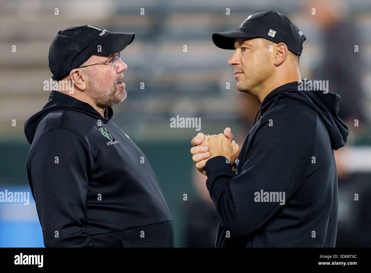 Charlotte head coach Tim Albin, left, talks to Tulane head coach Jon ...