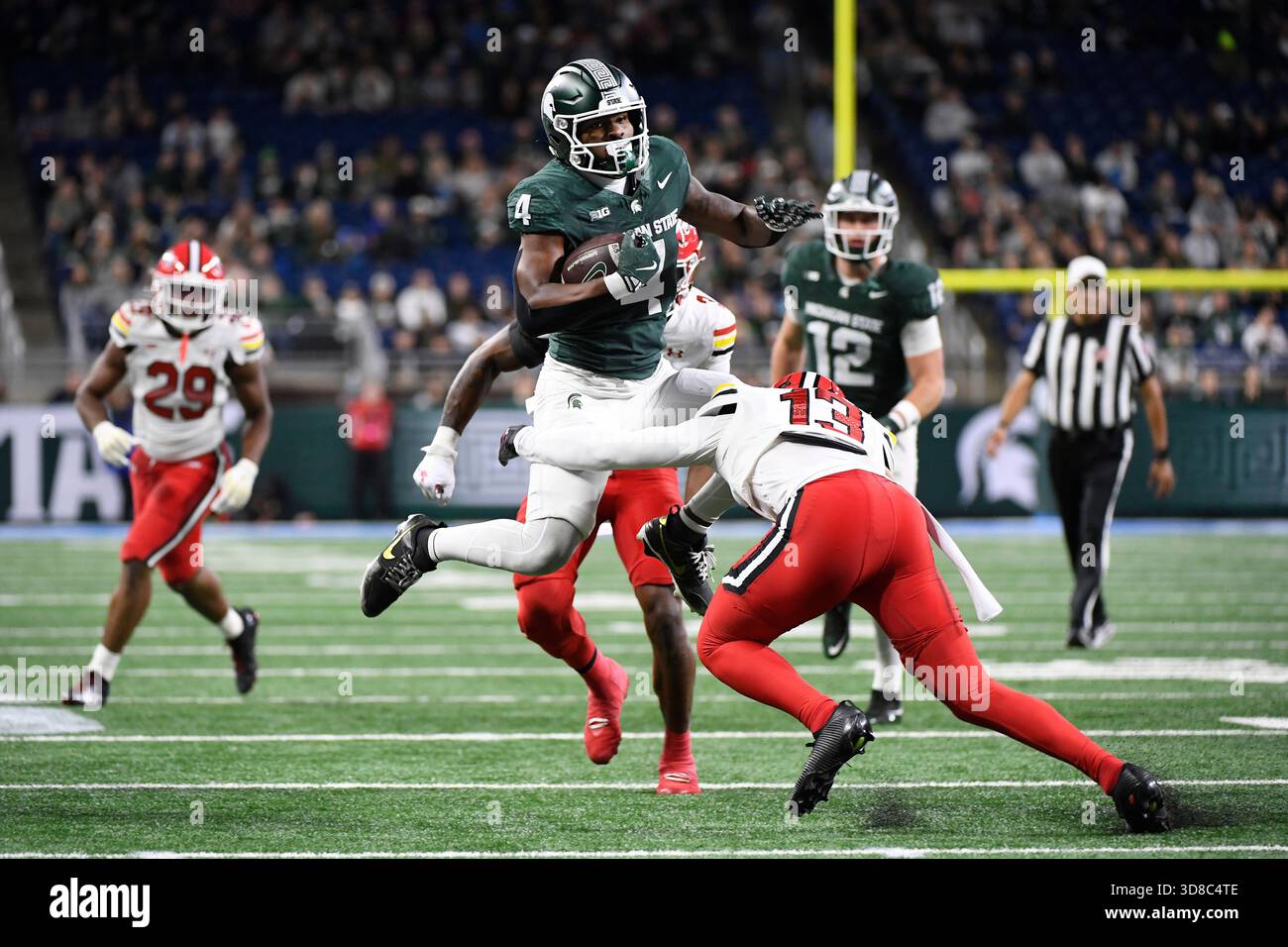 Michigan State running back Elijah Tau-Tolliver, left, tries to leap ...
