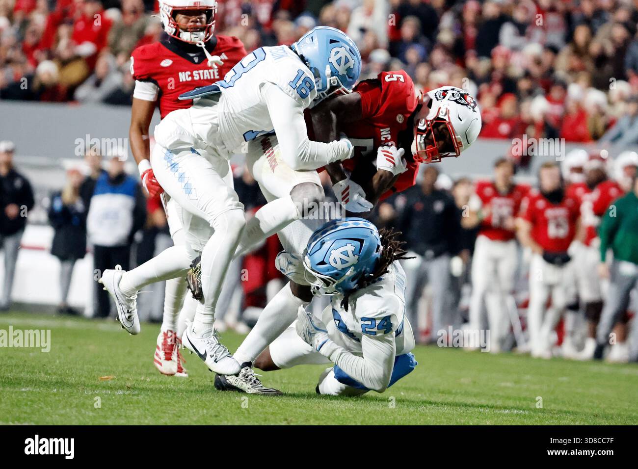 North Carolina State's Noah Rogers (5) is tackled by North Carolina's ...