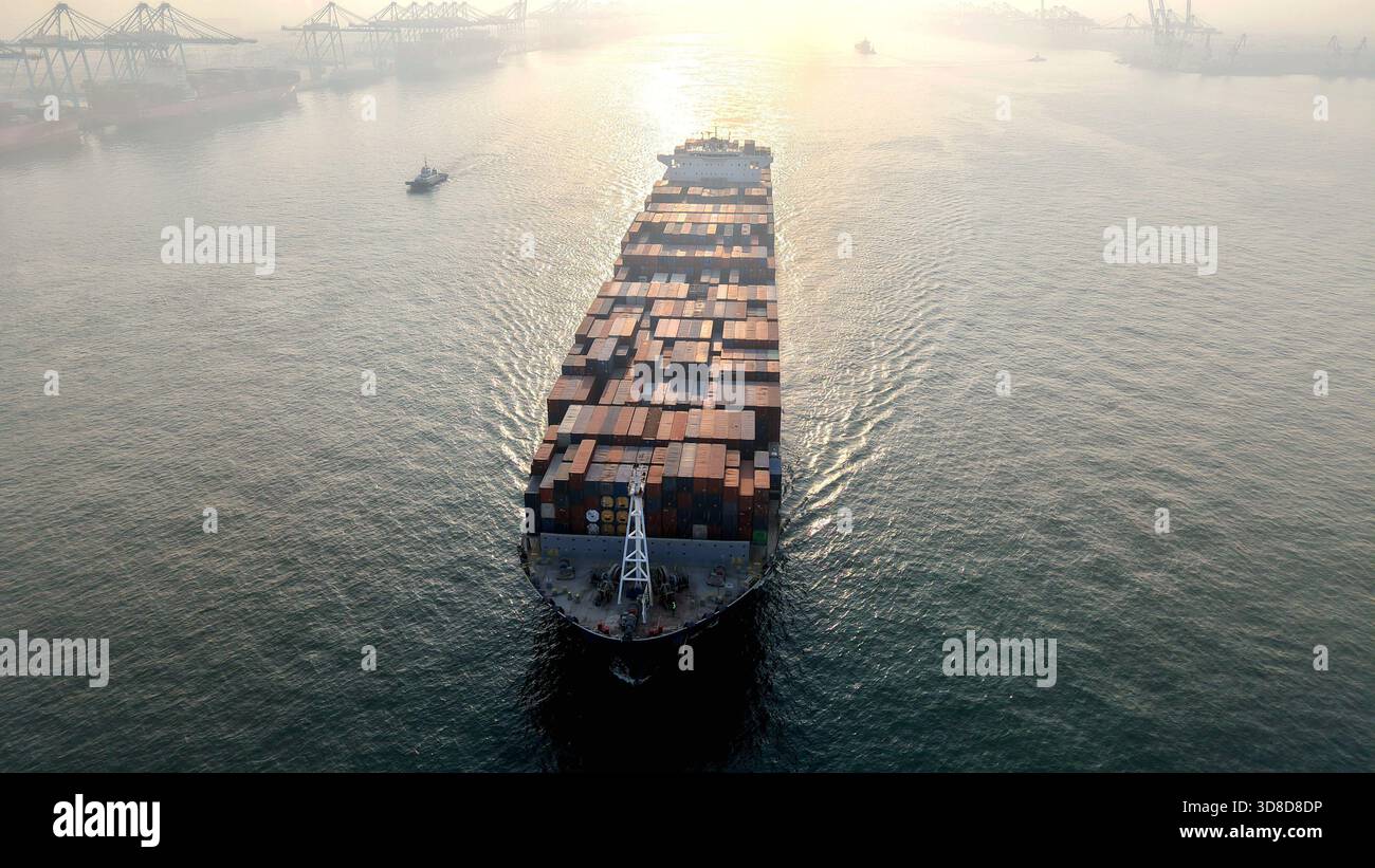 A container ship sails through the harbor in Qingdao in eastern China's ...