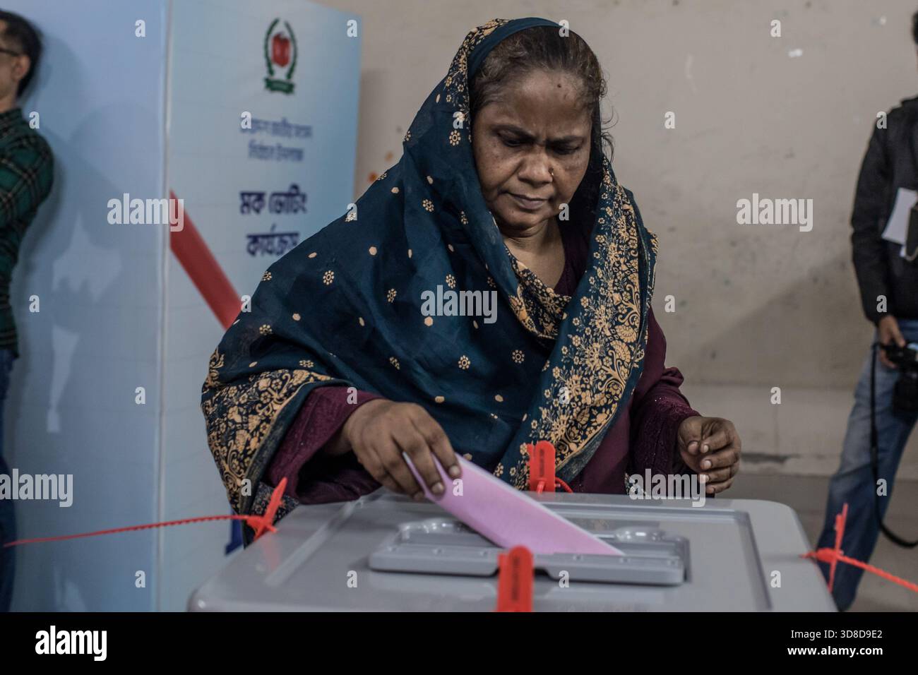 A woman casts her vote into a ballot box at a polling during a mock ...