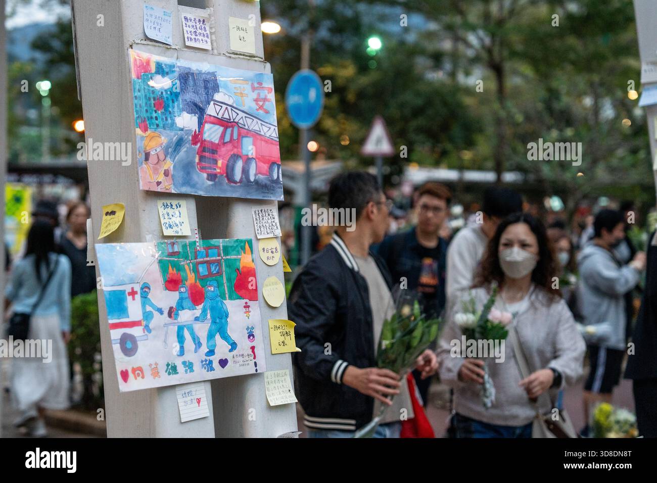 Drawings of emergency workers at a makeshift memorial near Wang Fuk ...