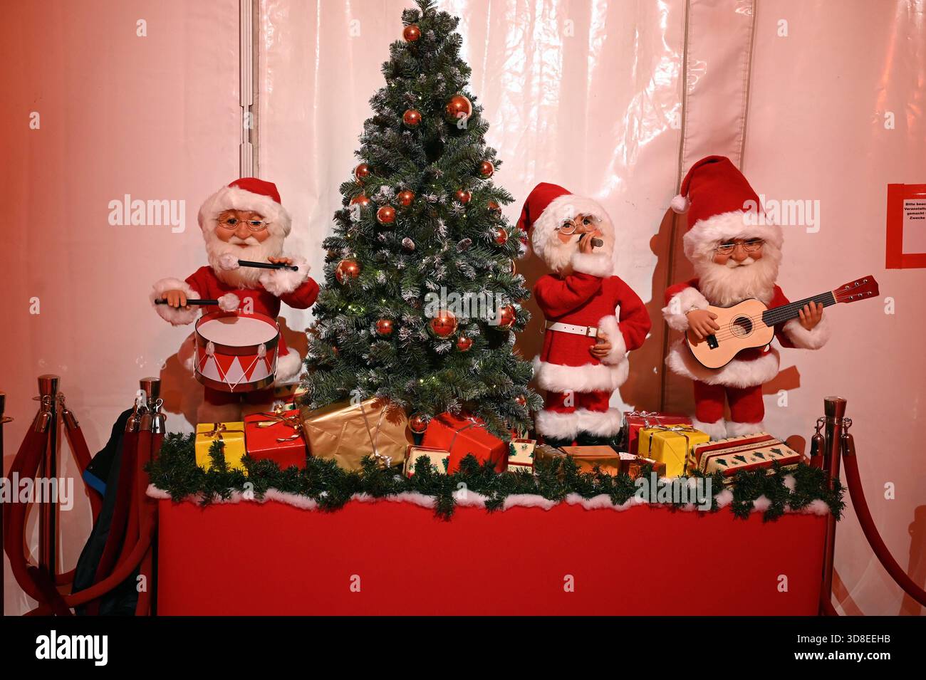 musizierende Weihnachtsmänner, Tannenbaum und eingepackte Geschenke als ...