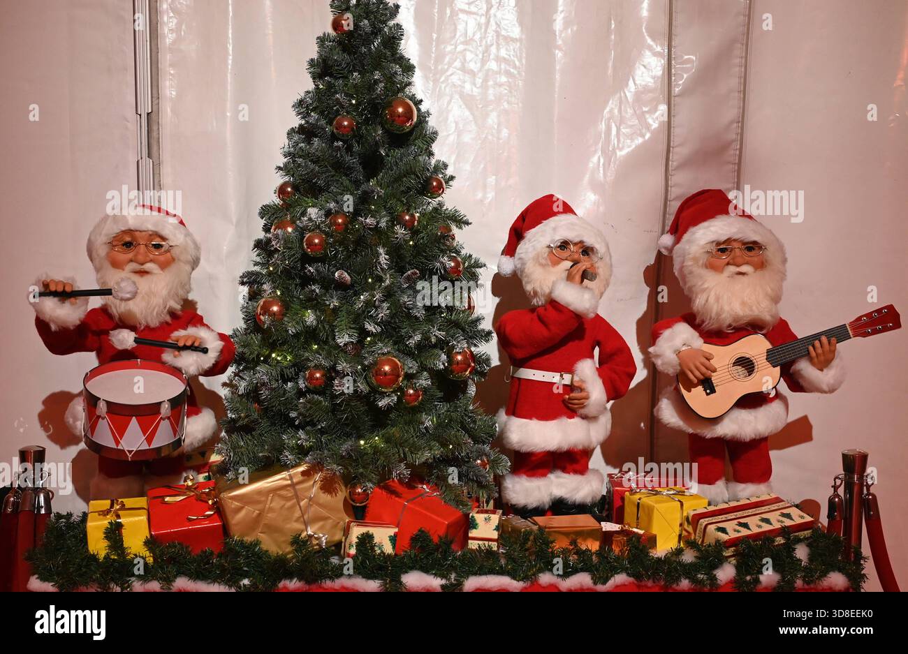musizierende Weihnachtsmänner, Tannenbaum und eingepackte Geschenke als ...