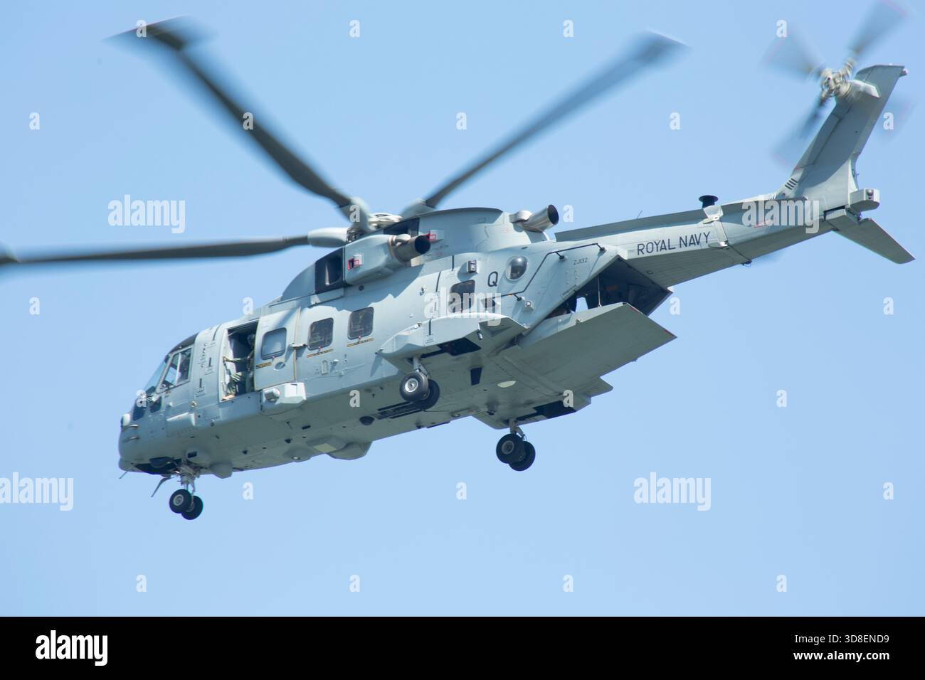 Military helicopter in flight with landing gear deployed against a ...