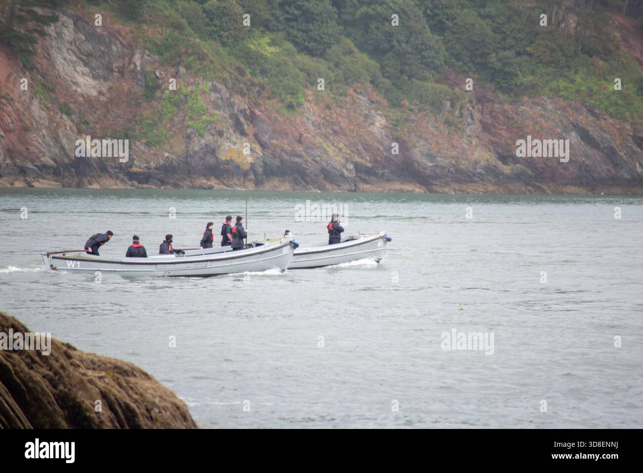 Two small boats carrying groups of people travelling across calm ...